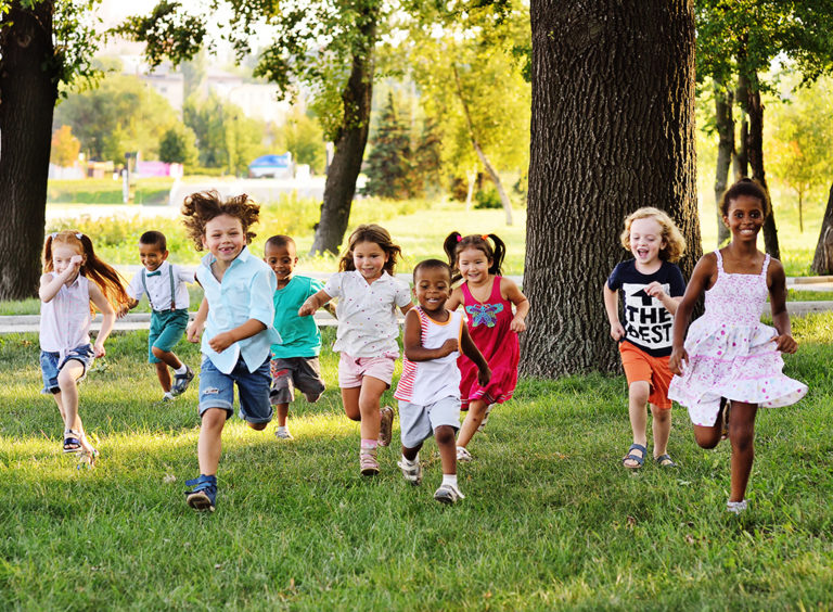 a group of preschoolers running on the grass in the Park. - Yellowstone ...